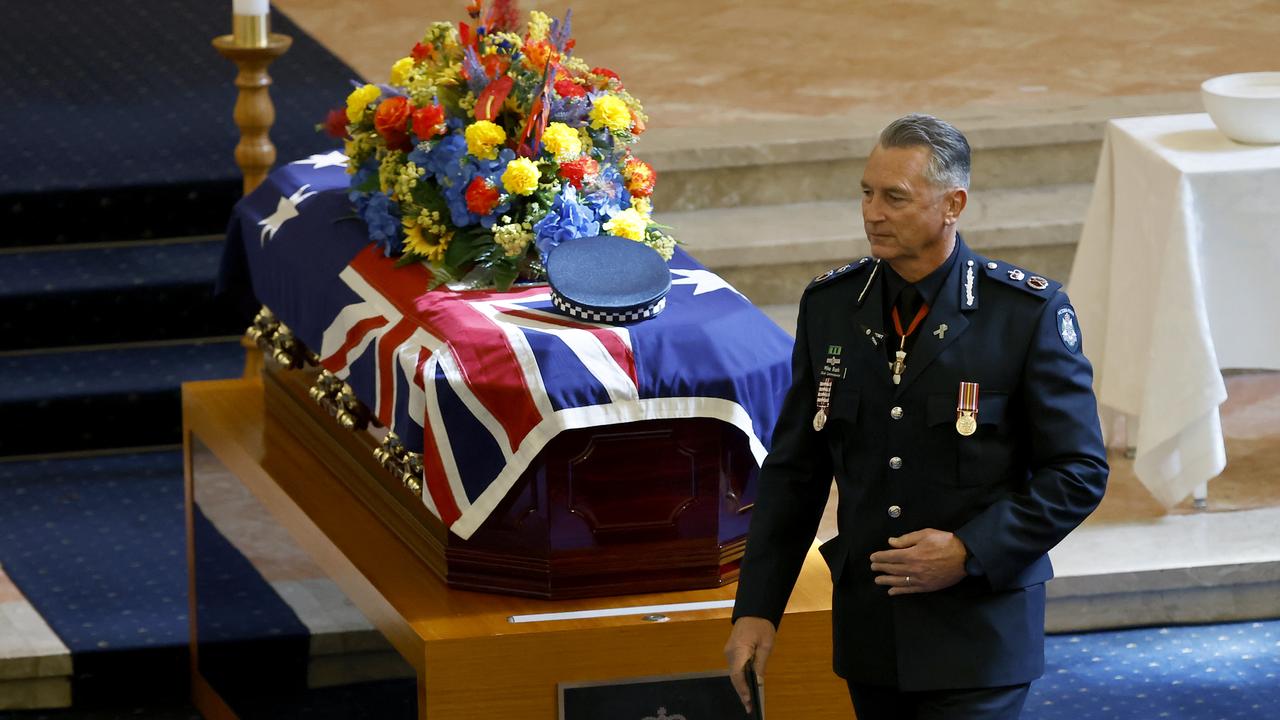 No let up in manhunt as thousands honour slain officer